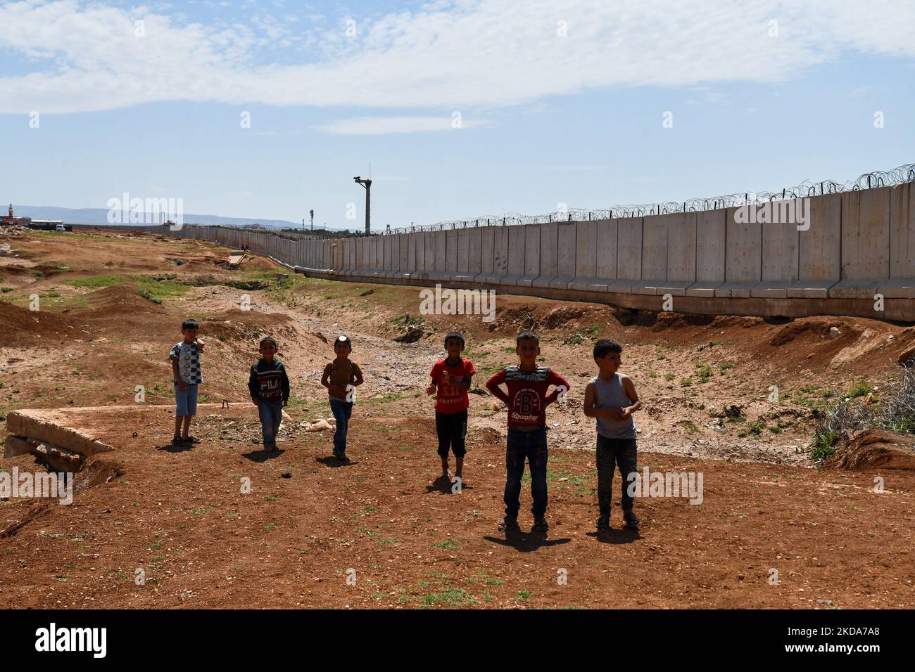 Camp children play on the wall separating Syria and Turkey near the ...