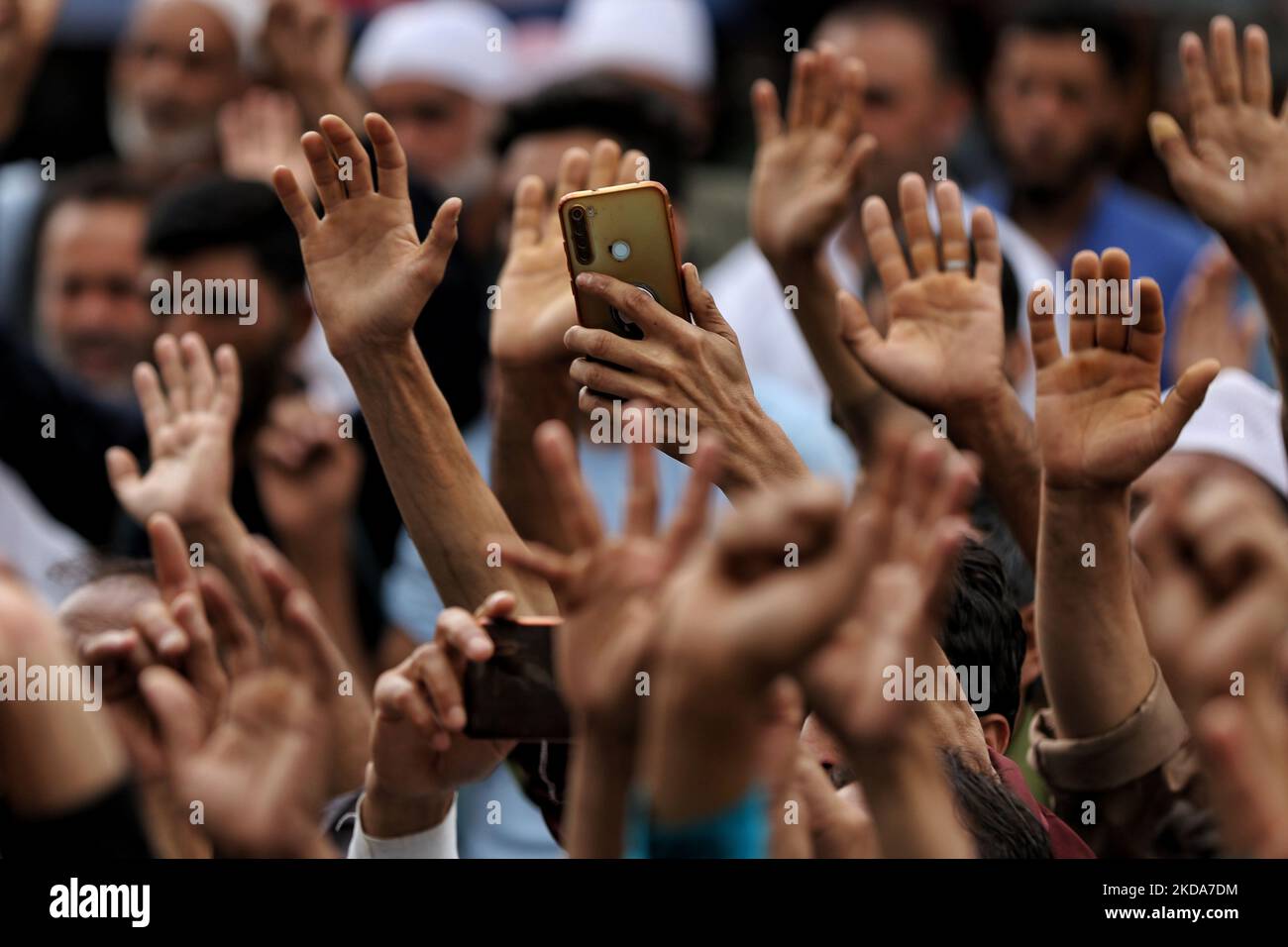 People raise their hands as they listen to senior political leader and ...