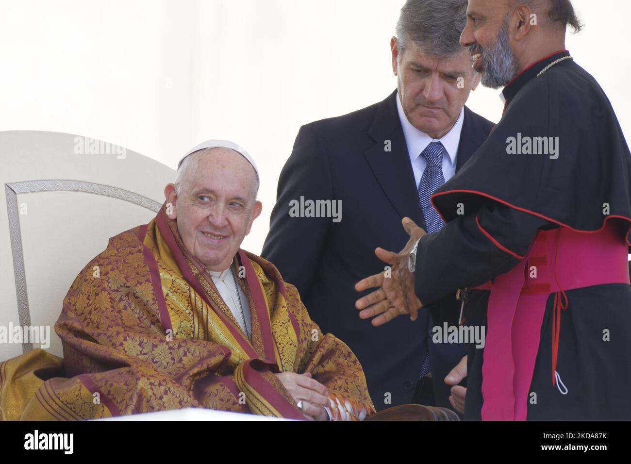 Pope Francis is helped to wear a garment he received from a Bishop ...