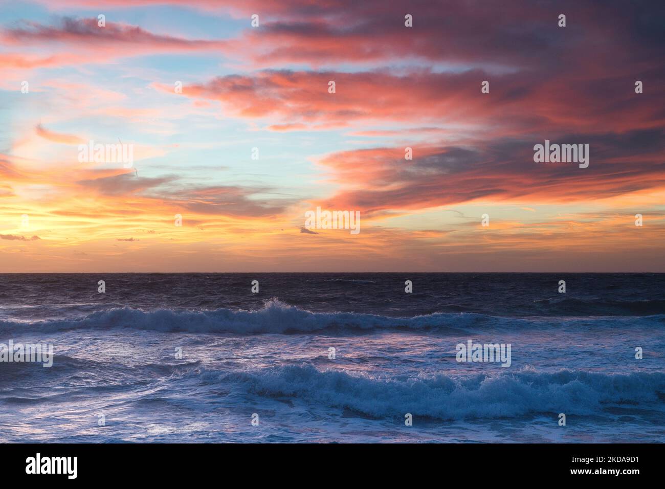 An aerial view of sea waves breaking beach during sunset Stock Photo ...