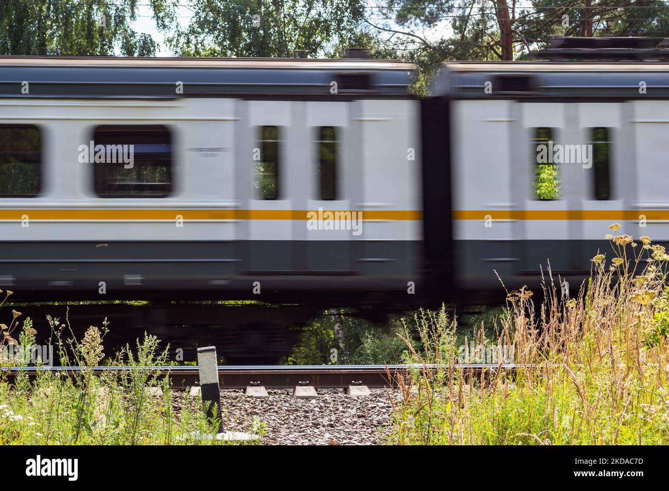 Electric train moving at speed on the railroad, side view Stock Photo ...
