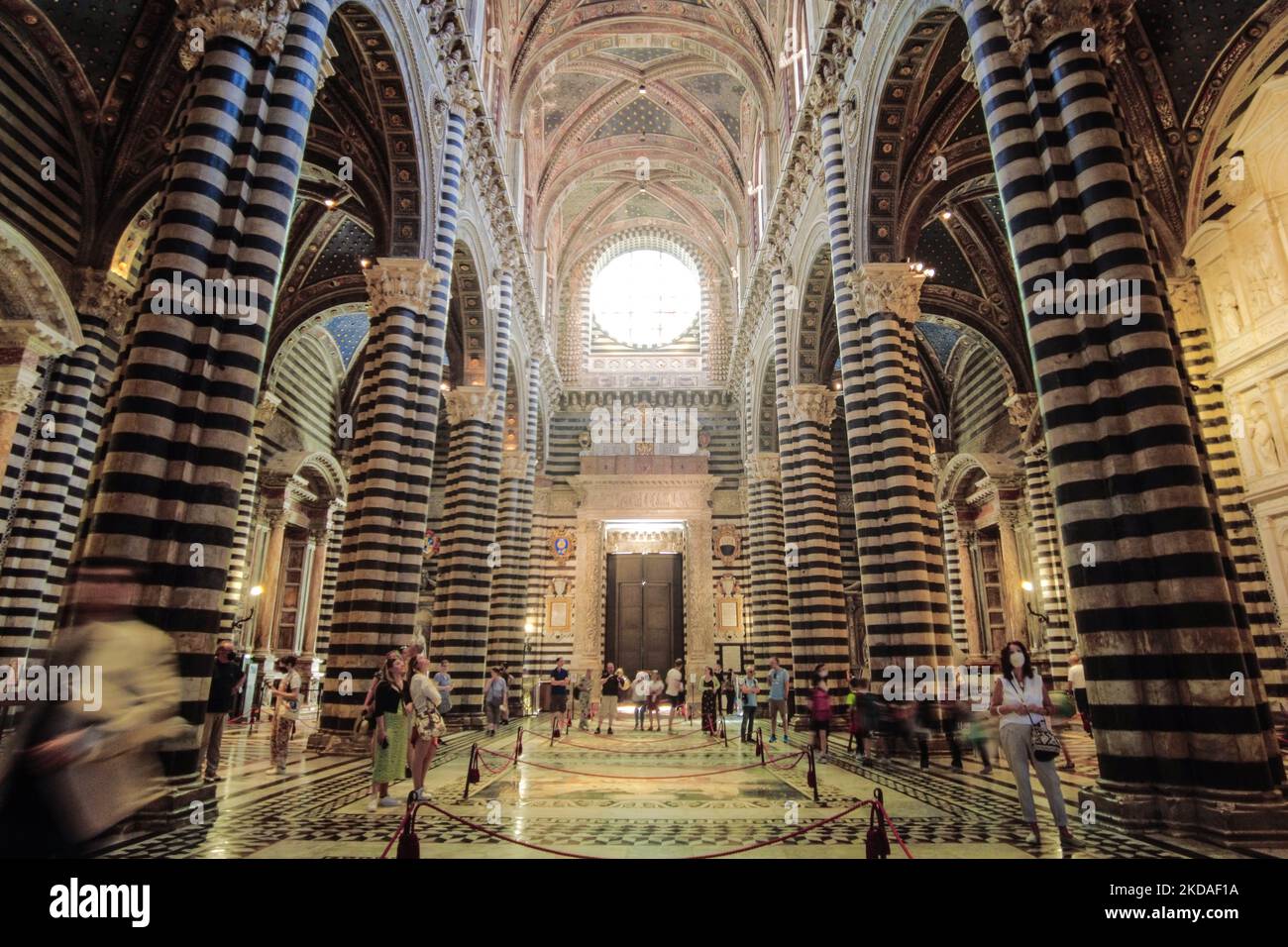 People and tourists visiting interior of Duomo church in Siena (Tuscany ...