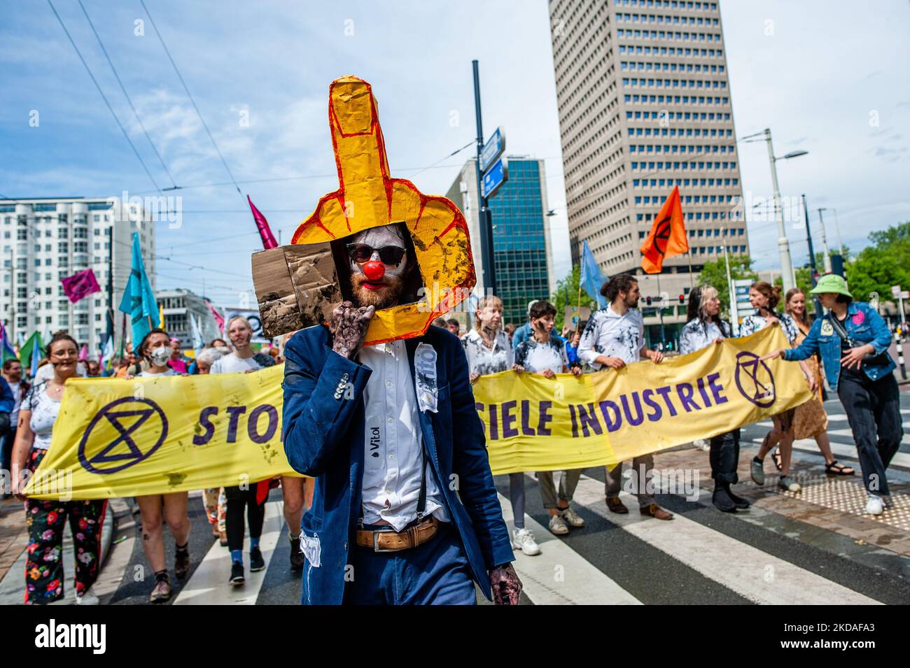 A XR activist is wearing the logo of the international oil company ...