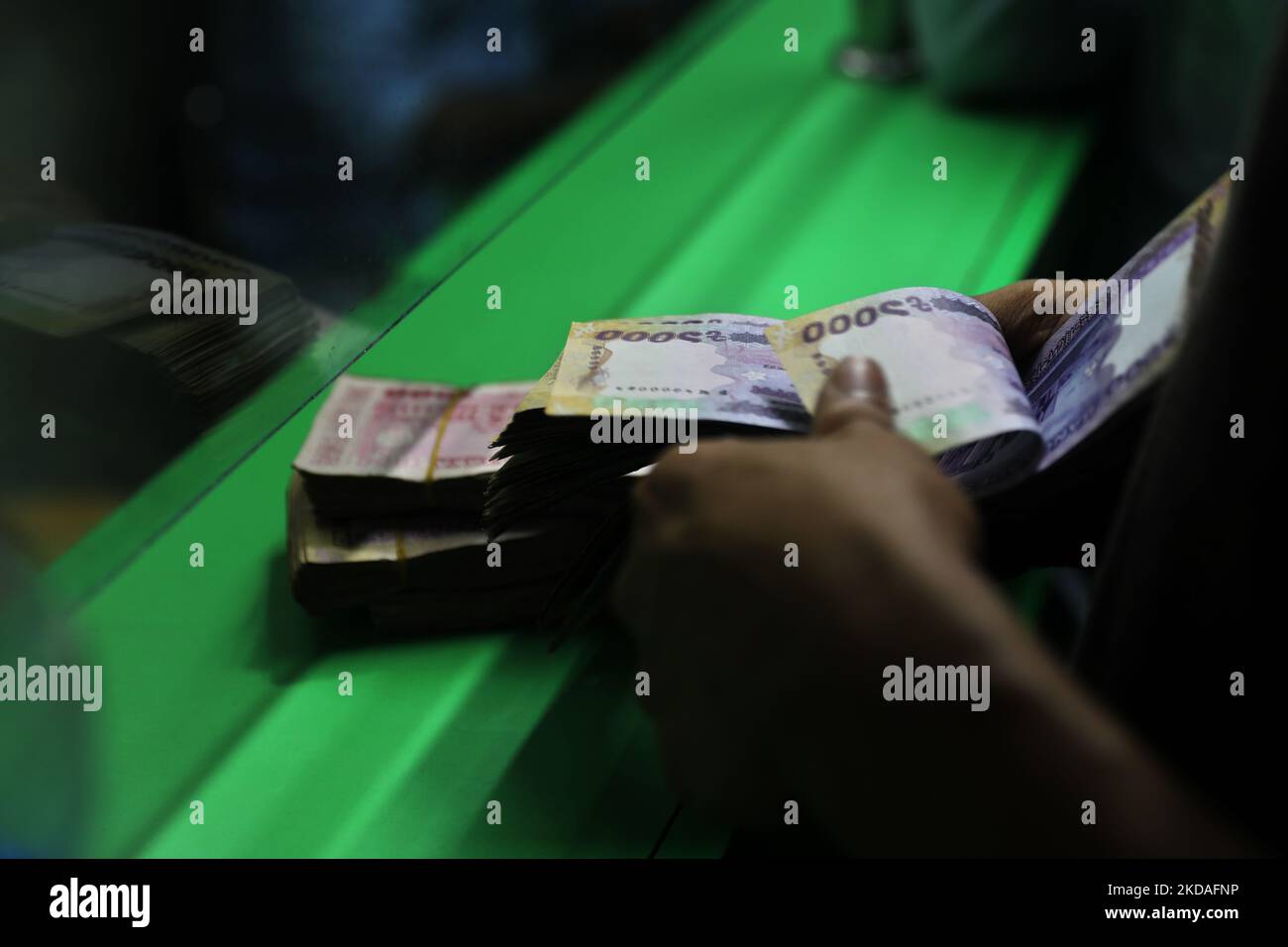 A customer counts Bangladeshi taka after exchanging dollars from a ...