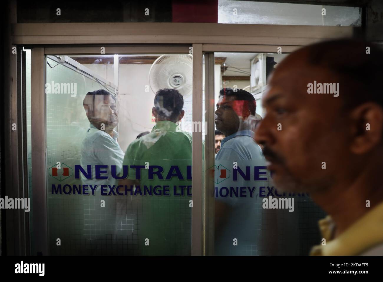 Customers gather at a money exchange booth to exchange money in Dhaka ...