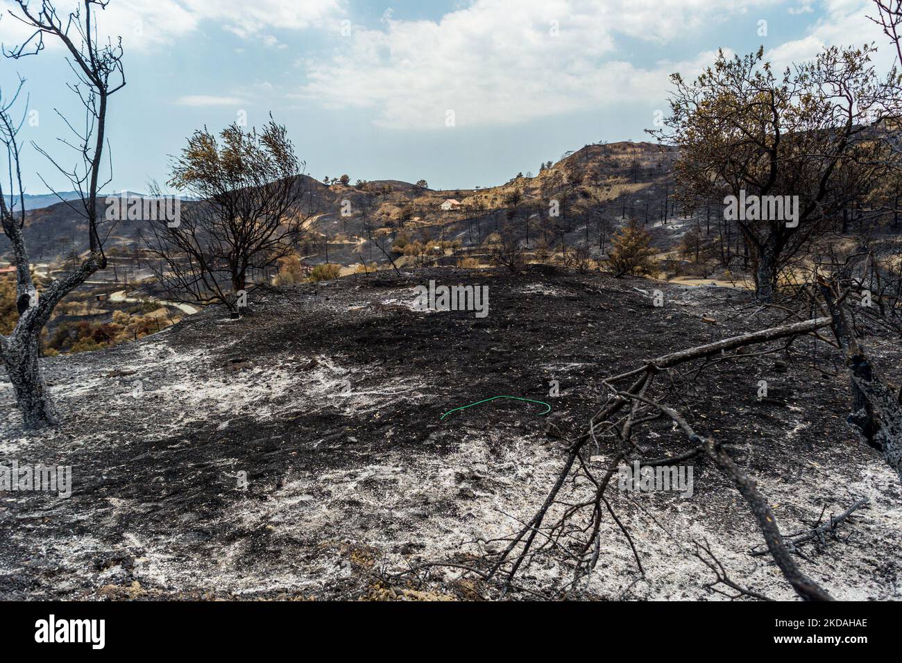 An untouched house in the distance is seen among a burnt area after a ...