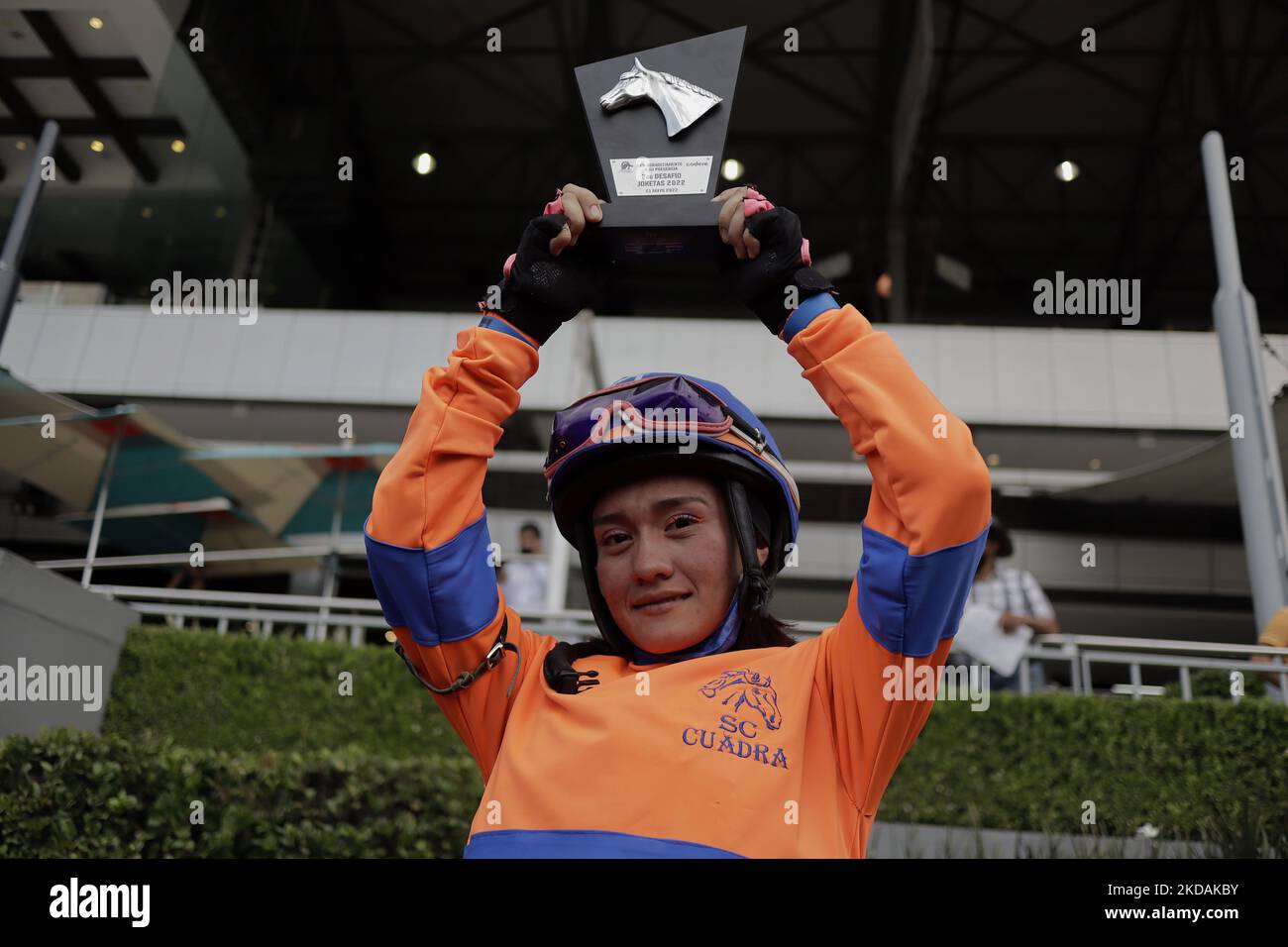 Michel Lara, jockey, raises the trophy during the award ceremony as ...