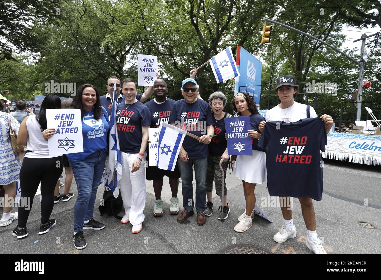 Yuval David poses with demonstrators displaing banners and “End Jew ...