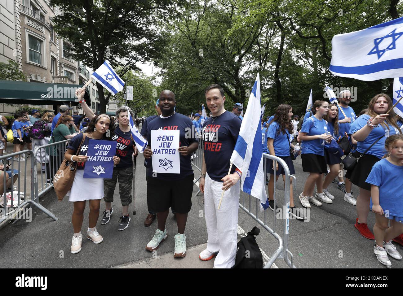 Yuval David poses with demonstrators displaing banners and “End Jew ...
