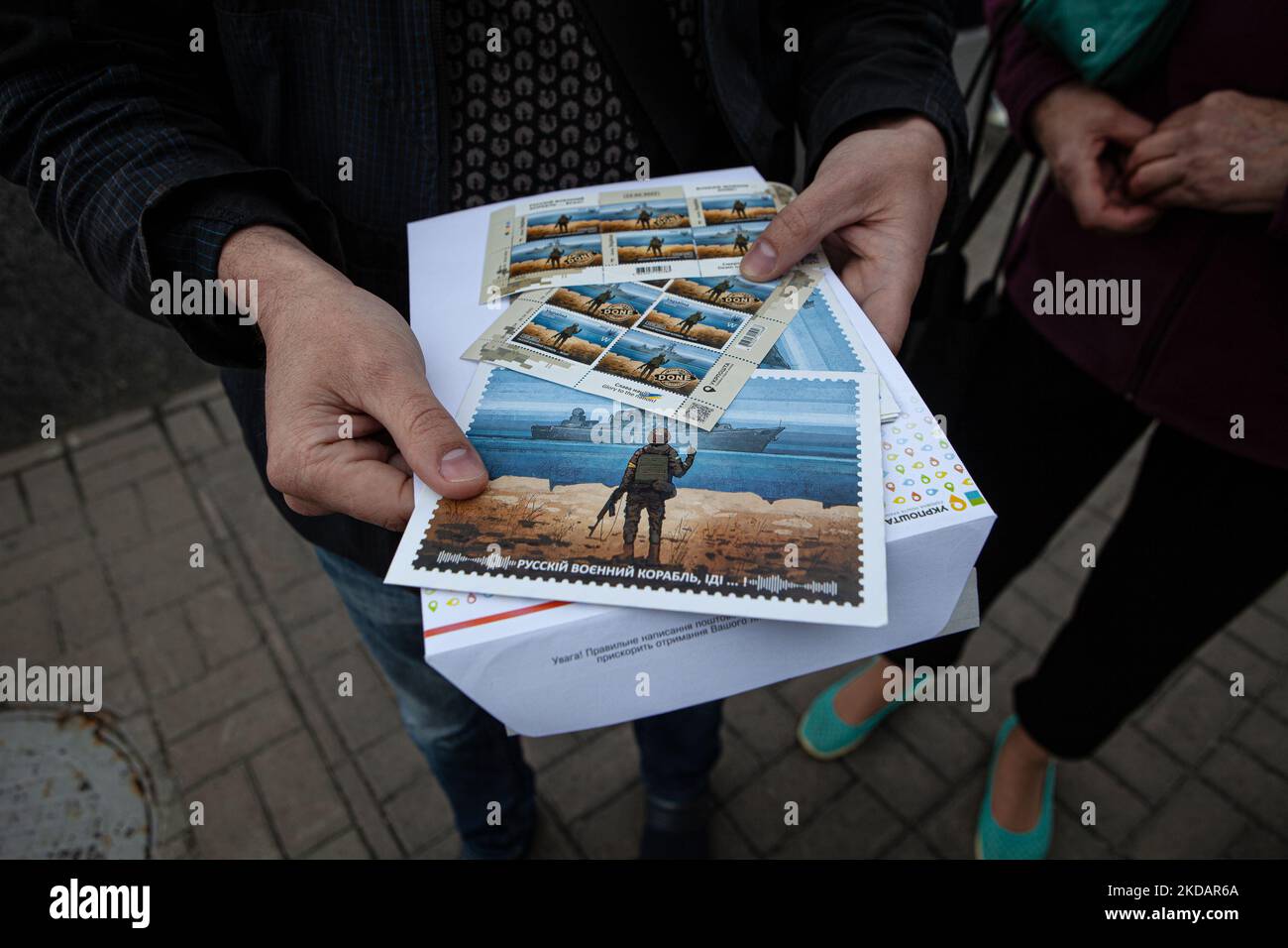 A man holds the latest edition of the "Russian Warship, go f ...
