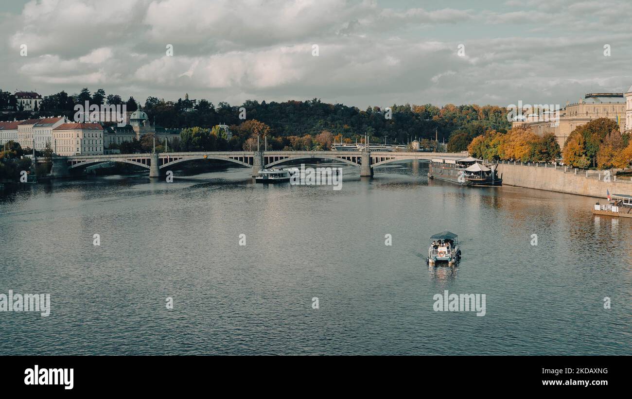 A scenic shot of a bridge over the Vltava river with ships in Czech ...