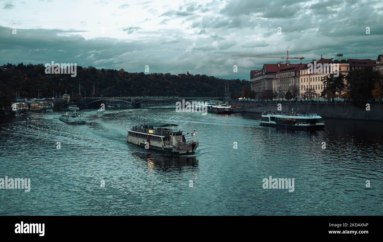 A scenic shot of a bridge over the Vltava river with ships in Czech ...