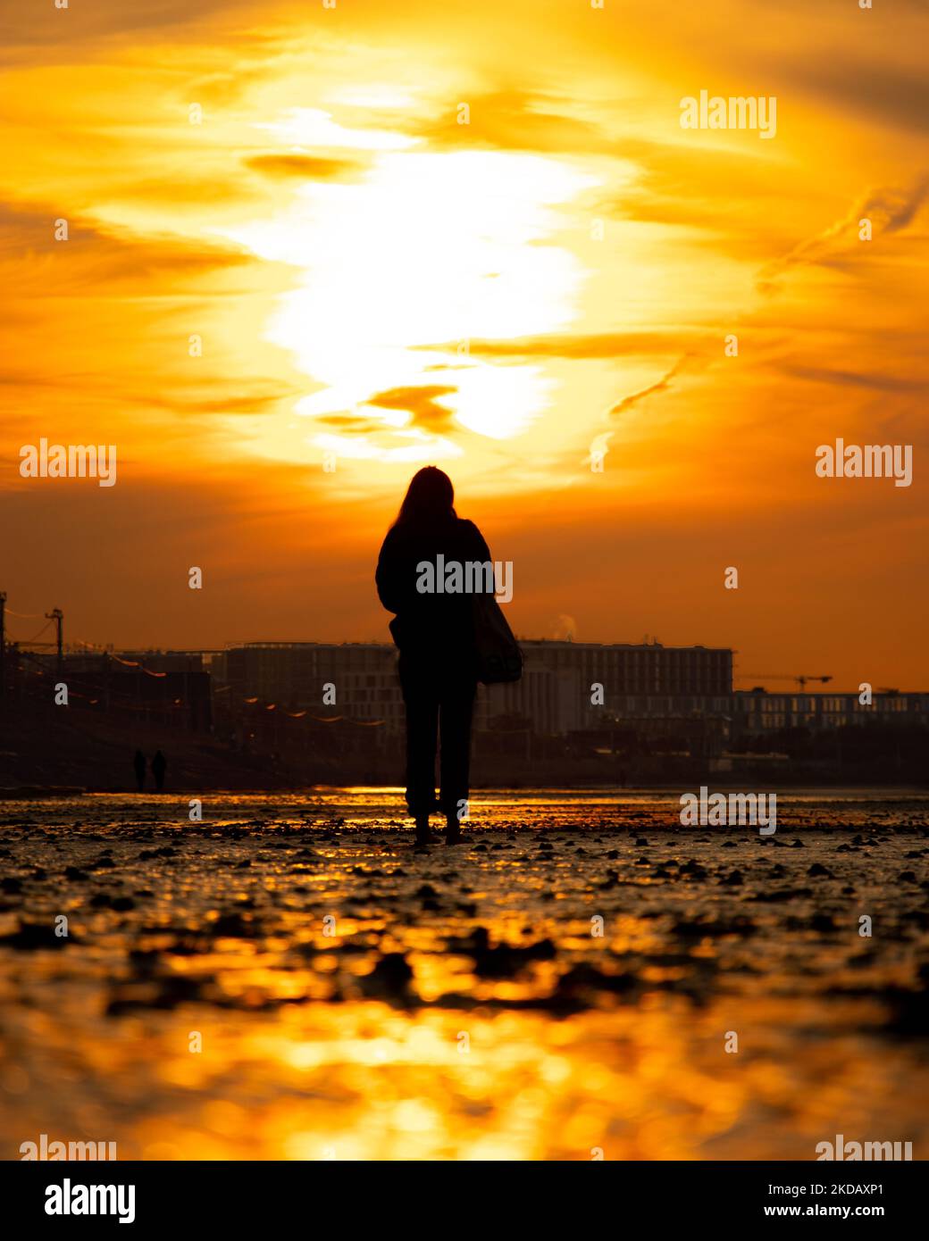 A silhouette of a woman on the beach at firey sunset Stock Photo - Alamy