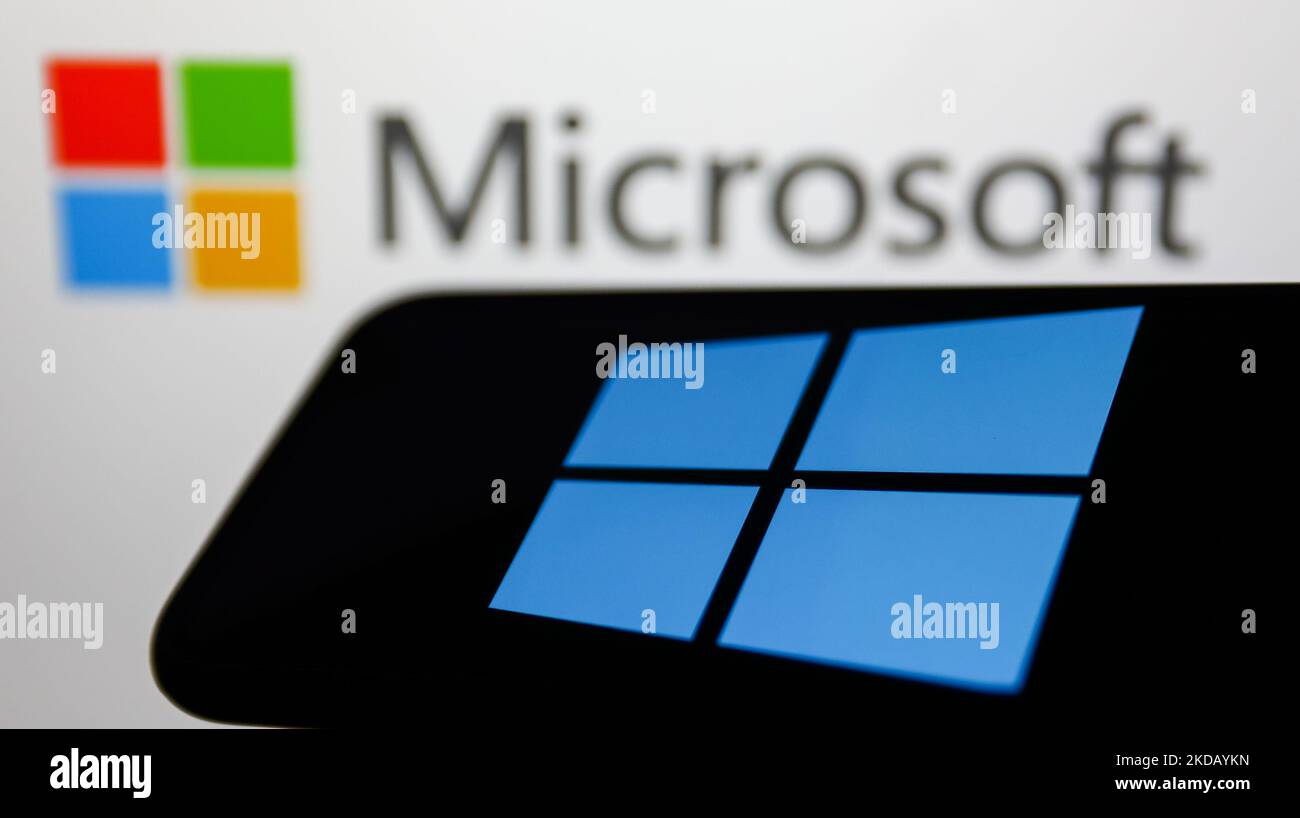 Windows logo displayed on a phone screen and Microsoft logo displayed ...