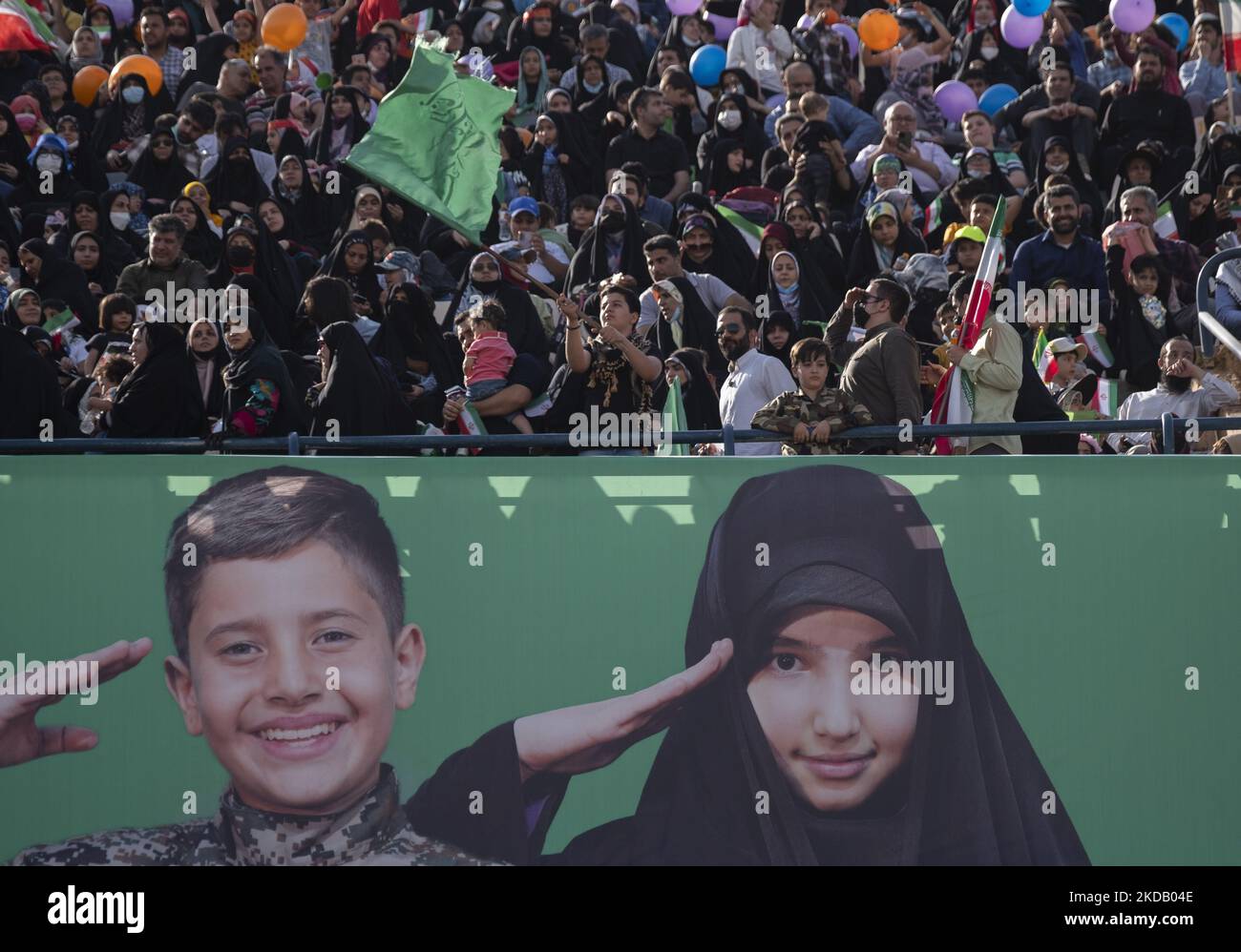 An Iranian schoolboy waves a religious flag while taking part a ...