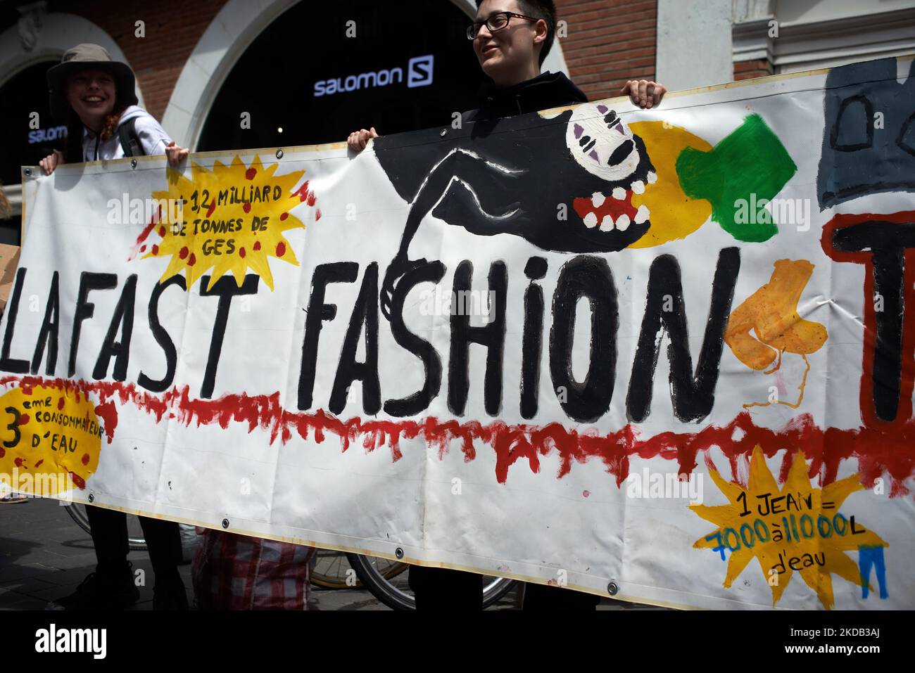 Activists hold a banner in front of the SHEIN poop-up store denouncing ...