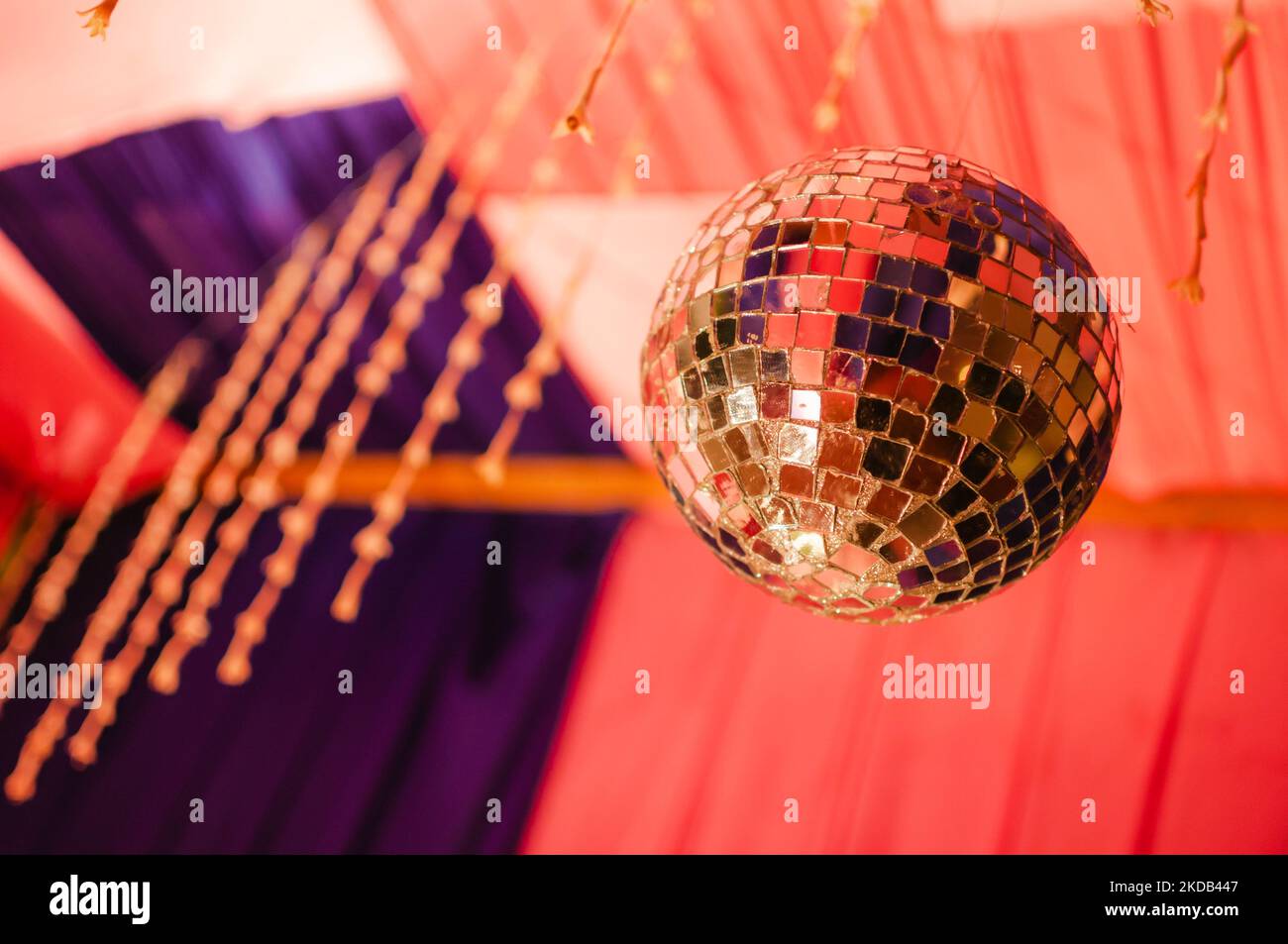 A Disco ball scatters red light in a dark room Stock Photo - Alamy