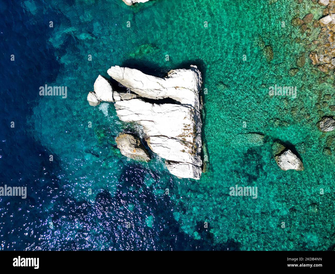 An aerial view of small white rock formation in shallow turquoise and ...