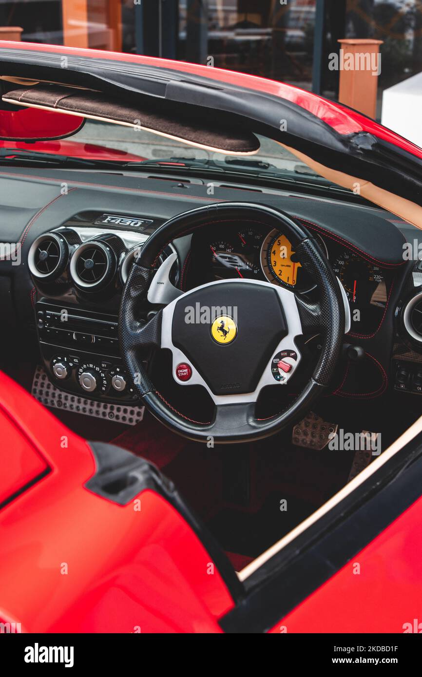 A vertical shot of a Ferrari old style seating with red detailing and ...