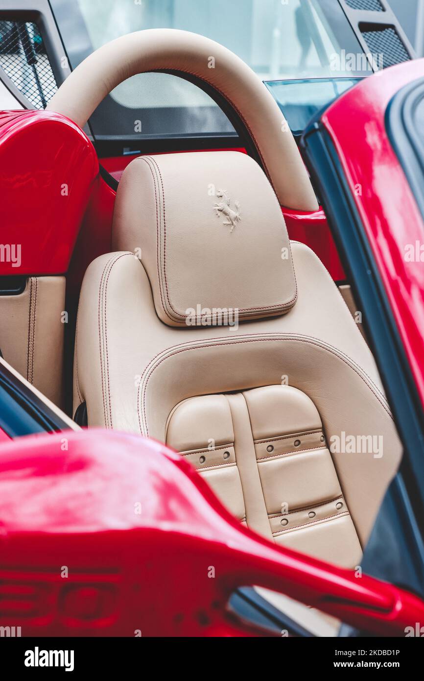 A vertical shot of a Ferrari old style seating with red detailing and ...