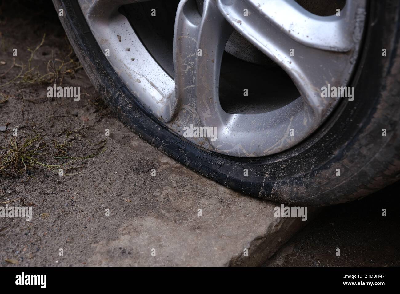 car flat tire. deflated wheel of a car with alloy disk Stock Photo - Alamy