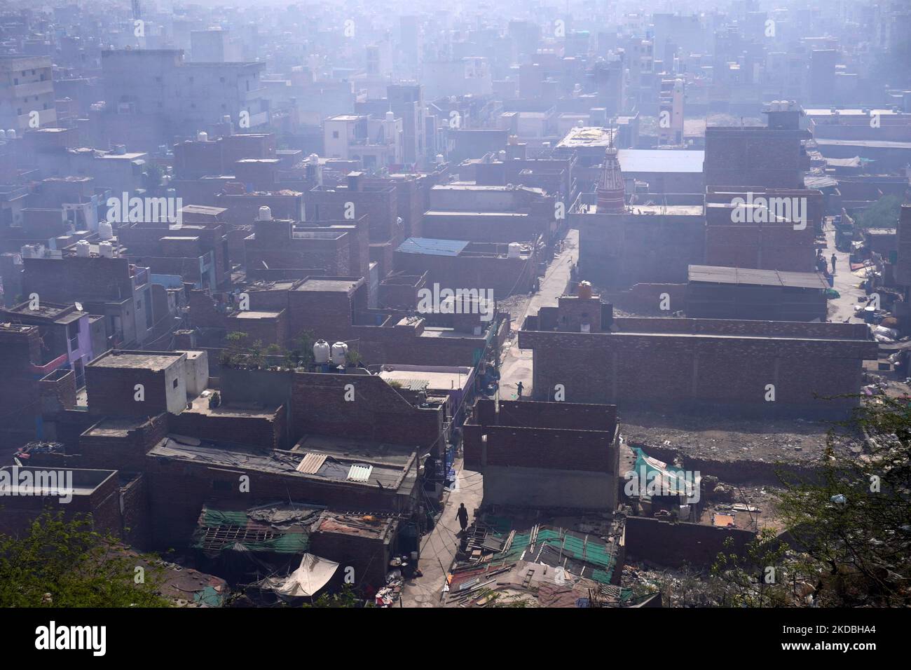 A boy flies a kite in street amidst thick smoke coming out of a fire at ...