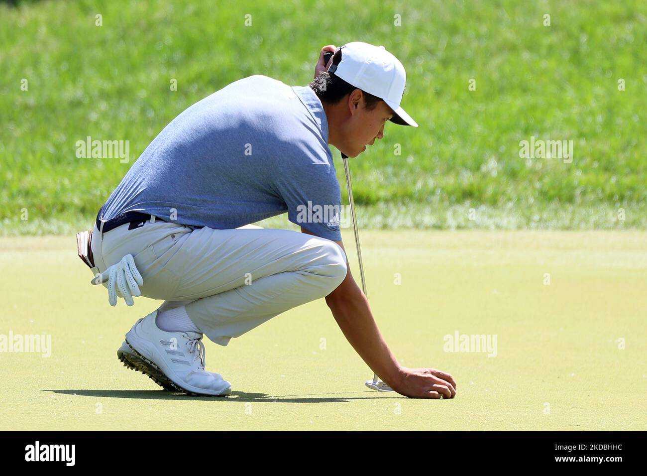 Brandon Wu of Scarsdale, New York places his ball on the 17th green ...