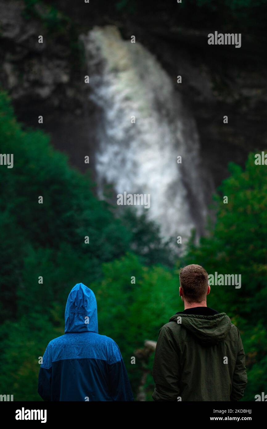 A back view of a couple watching the scenic waterfall Stock Photo - Alamy