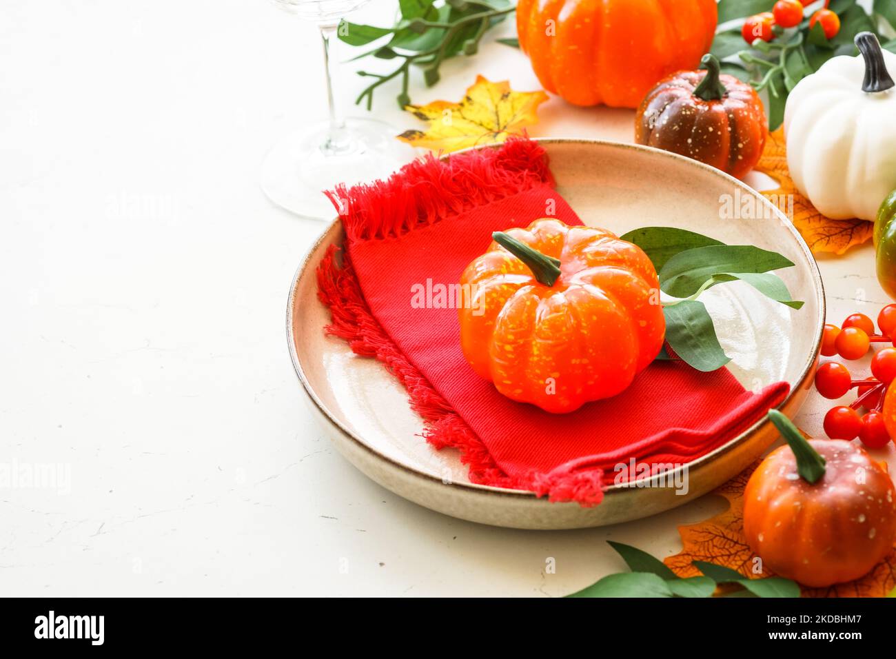 Autumn table setting. White plate, golden cutlery and fall decorations ...