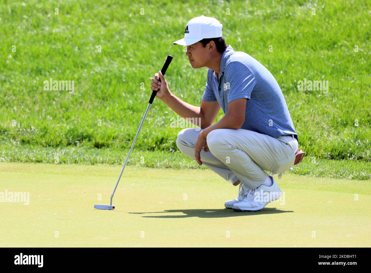 Brandon Wu of Scarsdale, New York lines up his putt on the 17th green ...
