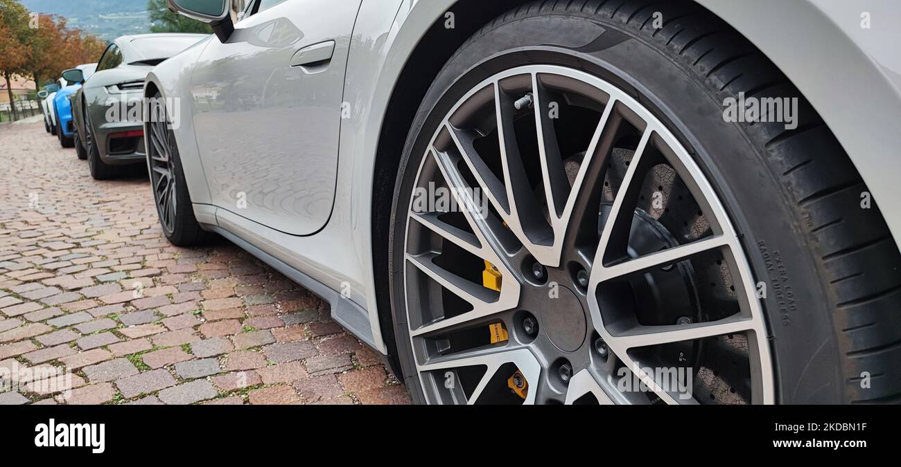 A low angle closeup shot of a white sports car wheel parked in the line ...