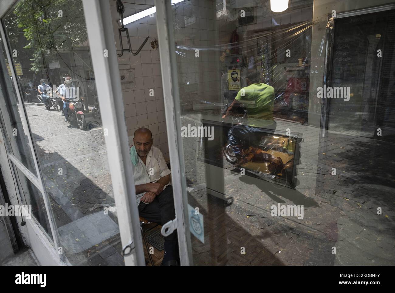 An Iranian butcher looks on while sitting at his butcher shop at the ...