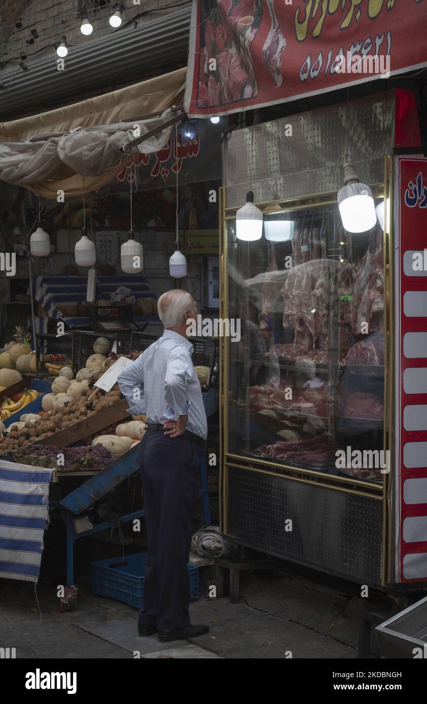 An Iranian elderly man looks at meats at a butcher shop window at the ...