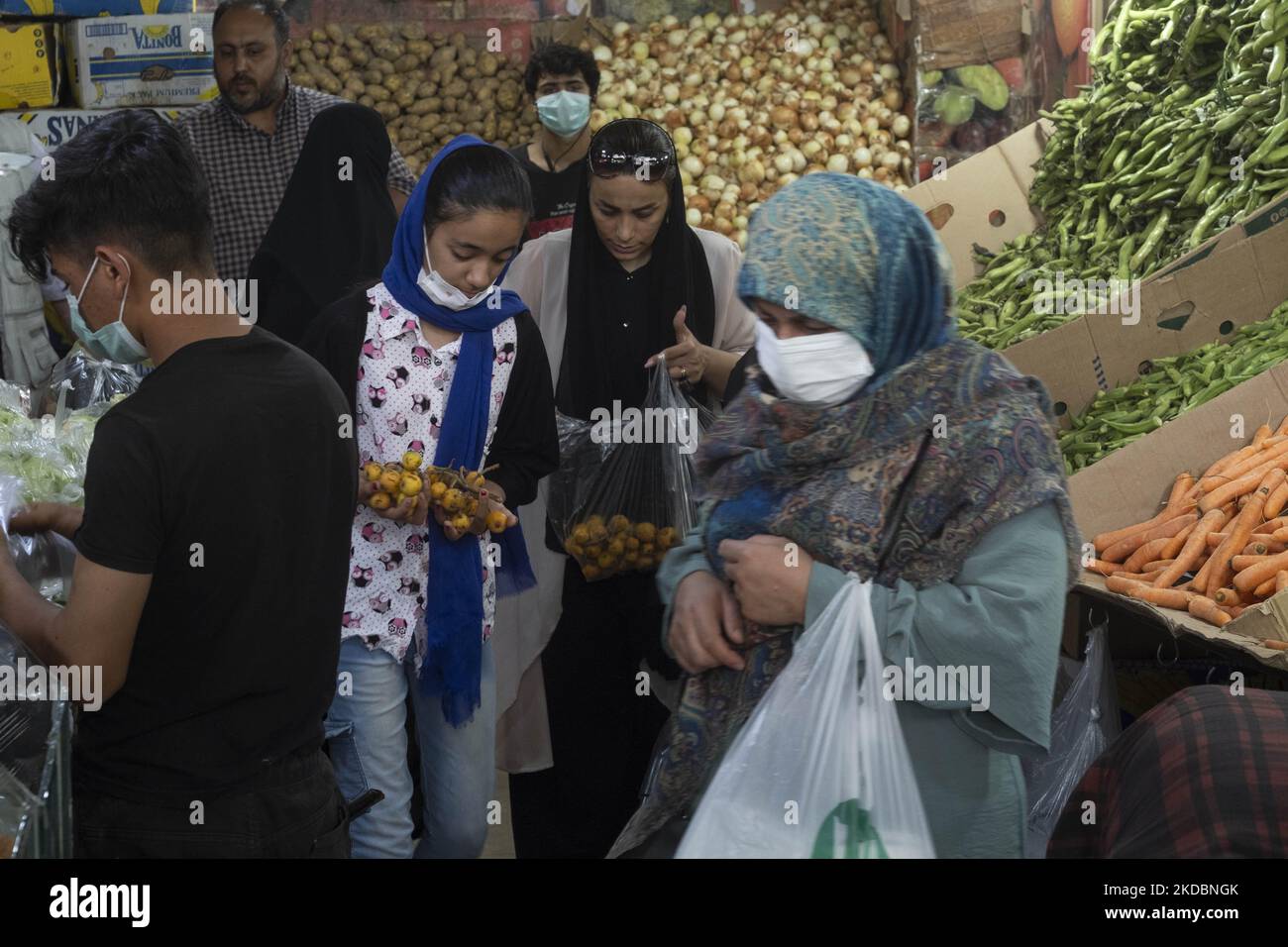An Iranian woman and her daughter carrying fruits while shopping at a ...