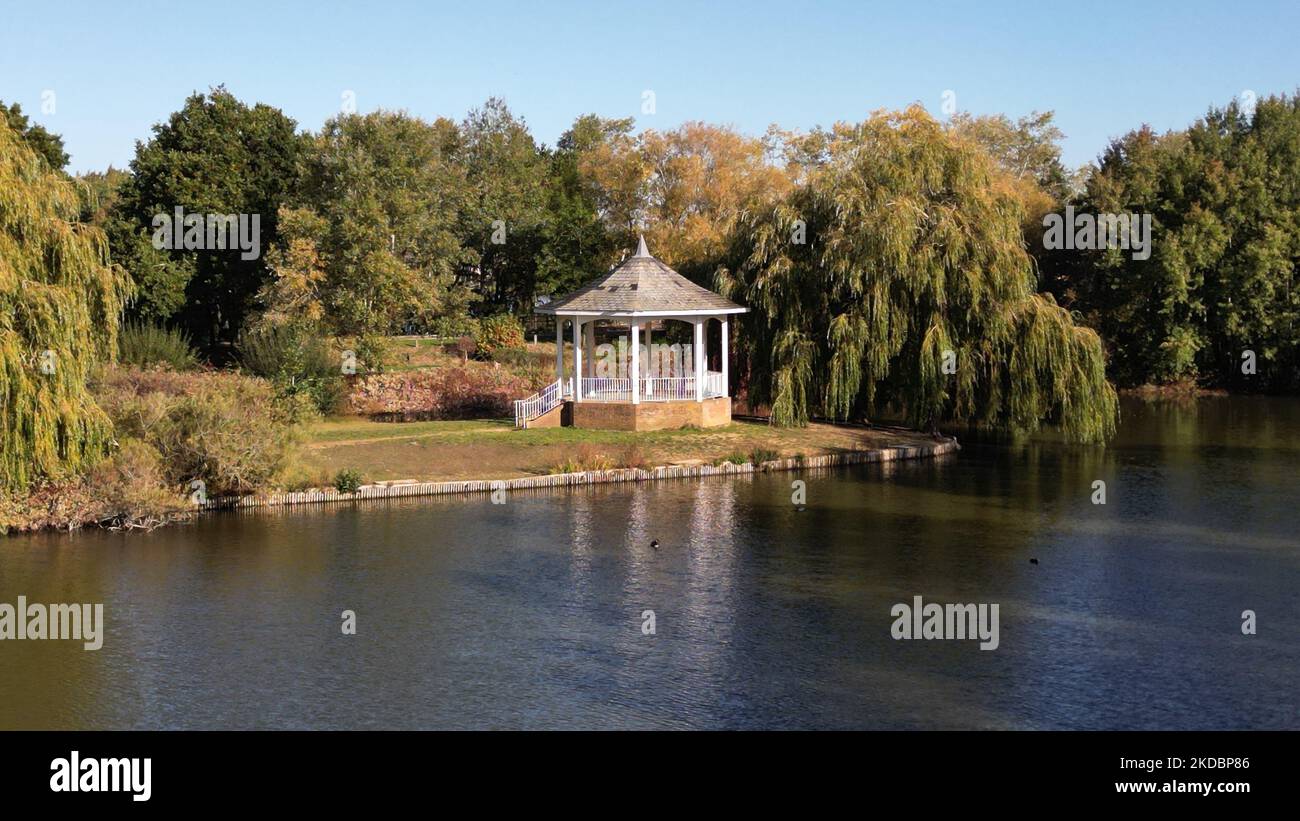 an aerial shot over a small bandstand near a lake in watermead park ...