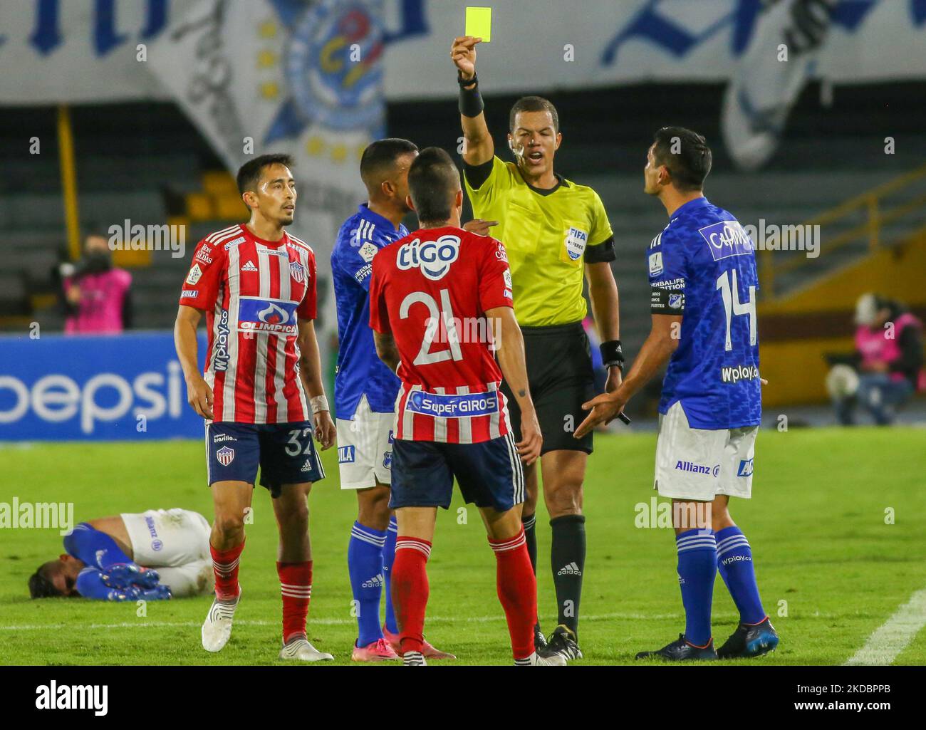 The referee Jhon Ospina Londoño gives a yellow card to the player of ...