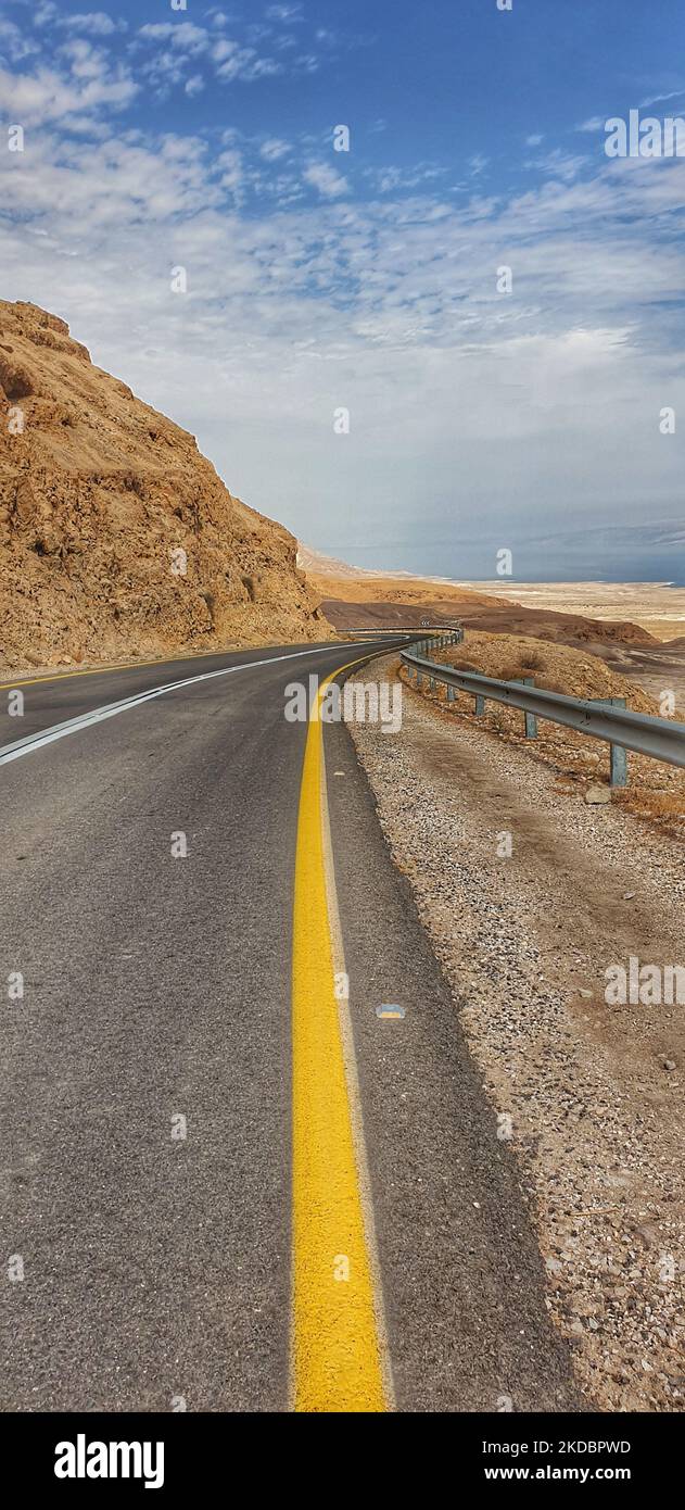A vertical shot of a narrow road with yellow lines on the asphalt Stock ...