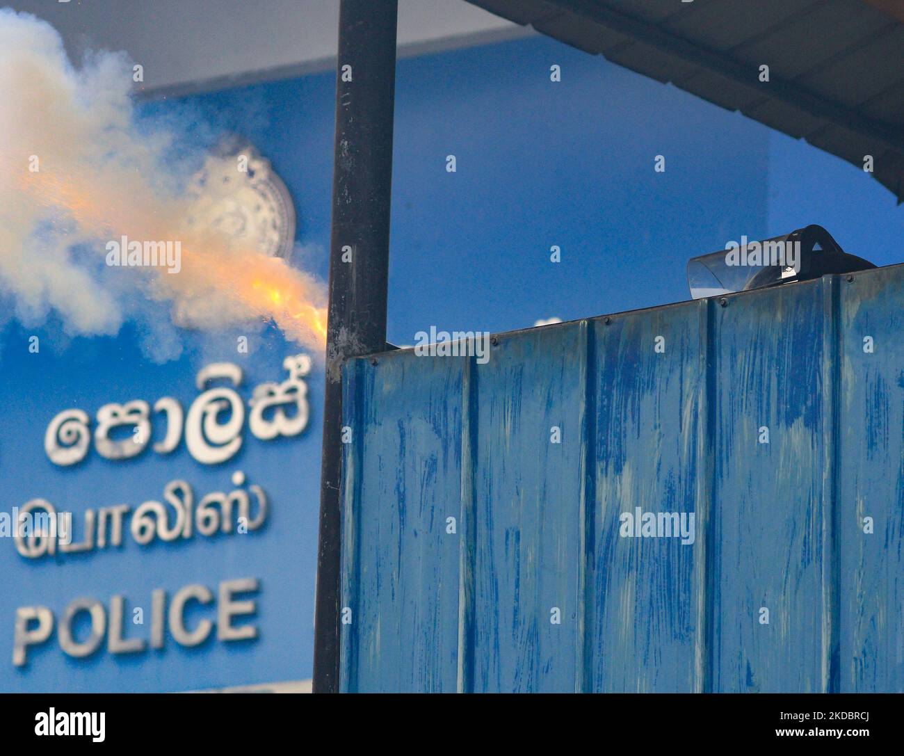 A Sri Lankan police officer fires a tear gas canister at the protesters ...