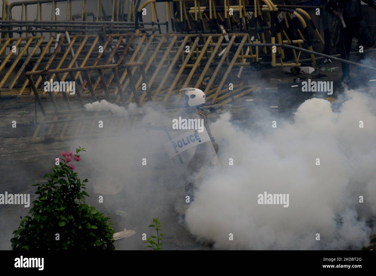 A Sri Lankan police officer throws a tear gas canister at the ...