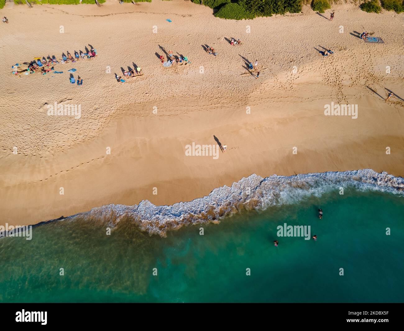 An aerial view of Papaoneone beach on Oahu with people enjoying the ...