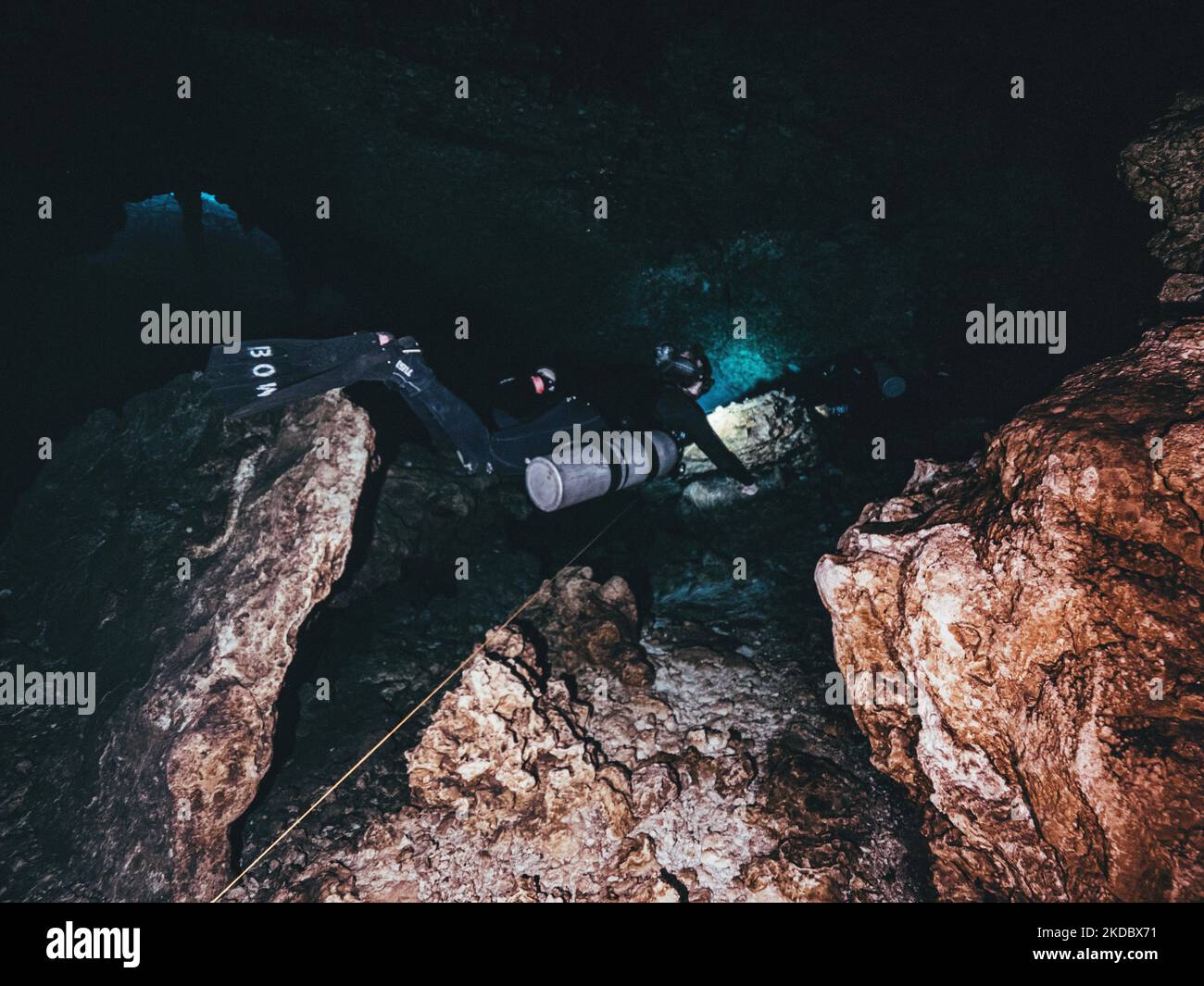 A scuba diver exploring the mysterious rocky cave Stock Photo - Alamy