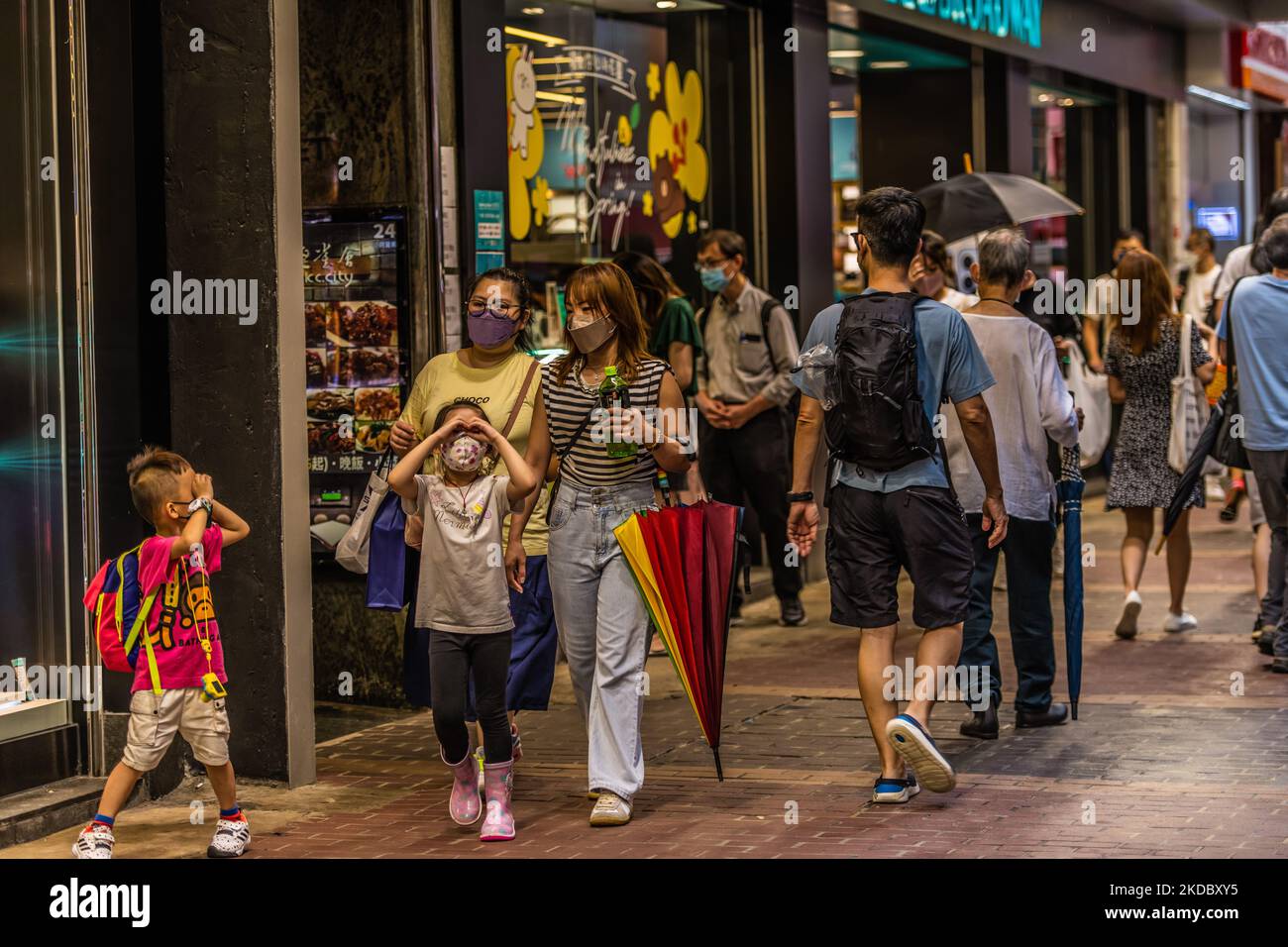 Hong Kong, China, 11 Jun 2022, A family wearing face masks walks on Sai ...