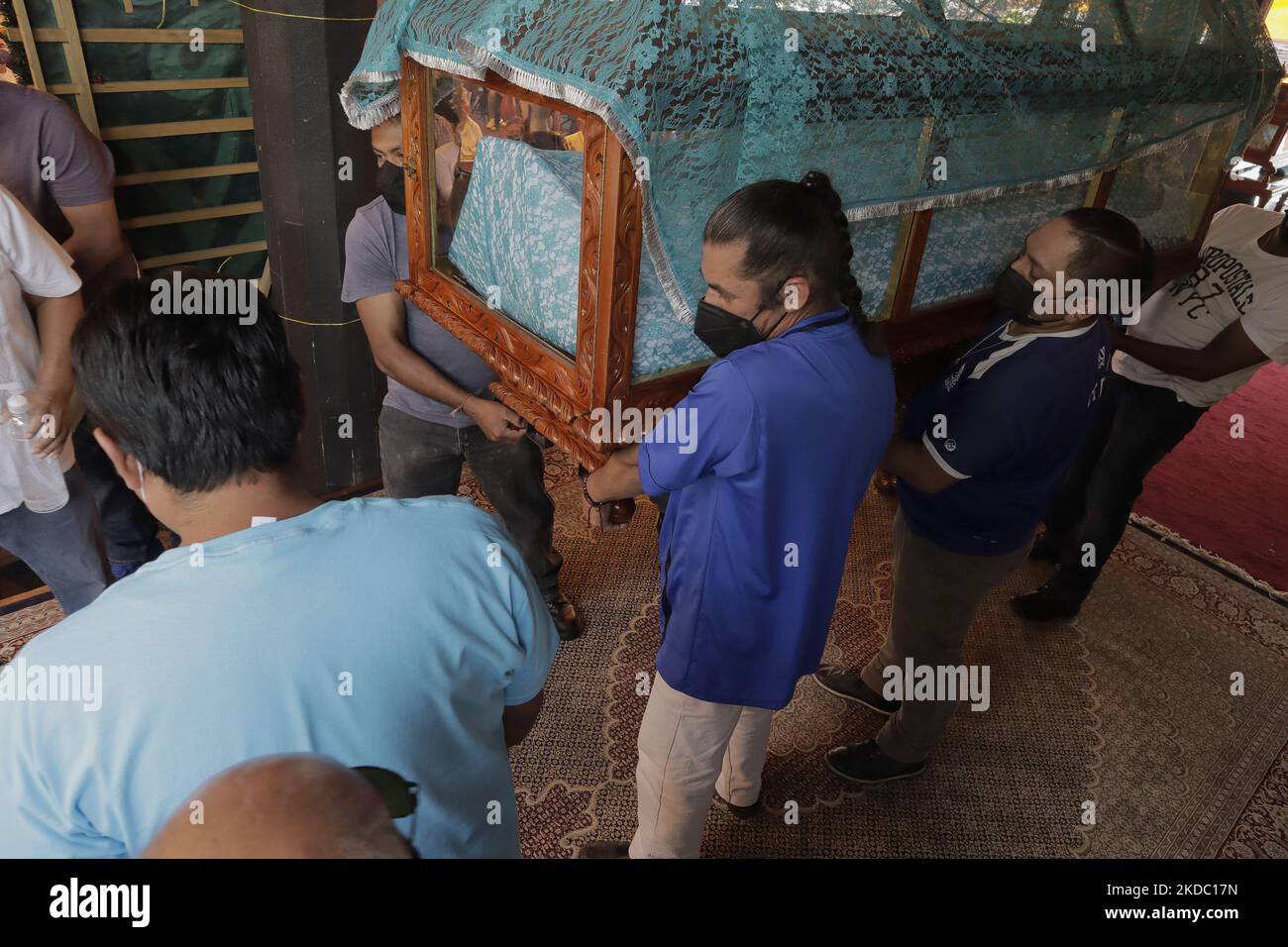 A group of people carry the image of the Lord of Calvary outside the ...