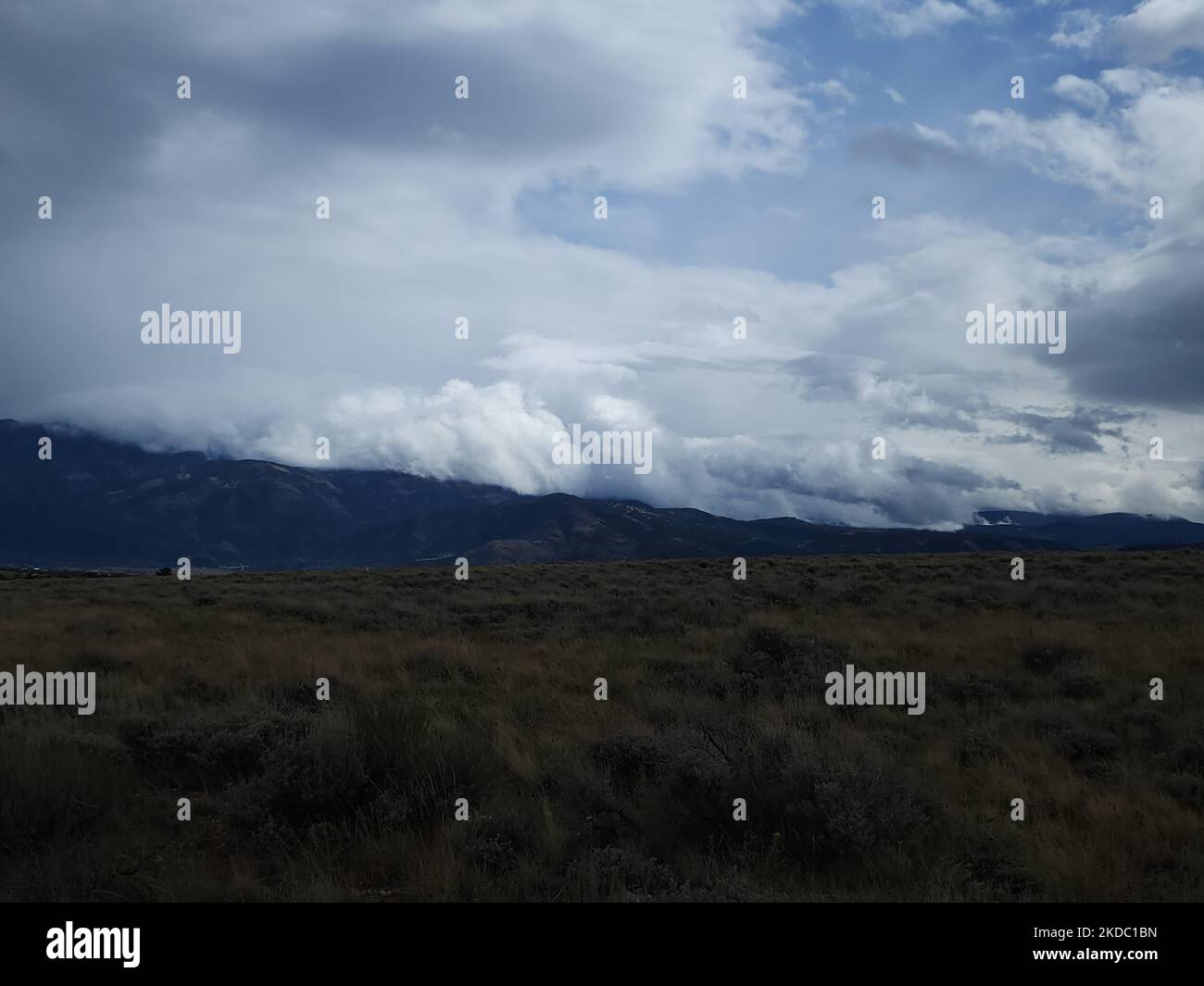 A landscape of a dry field against a cloudy gloomy sky Stock Photo - Alamy