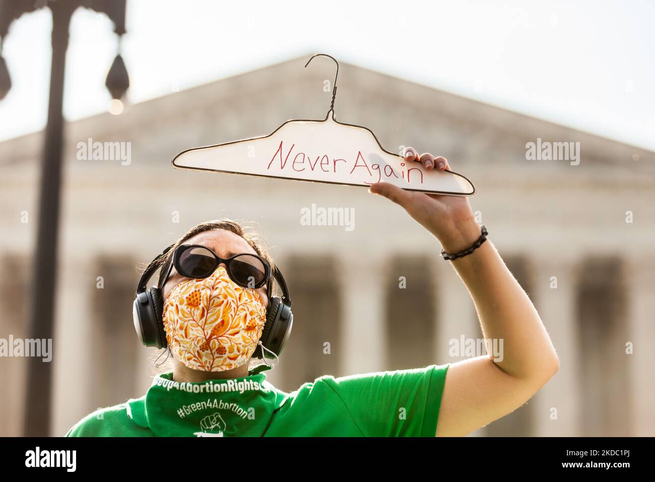 A protester with Rise Up for Abortion Rights holds a coat hanger with ...