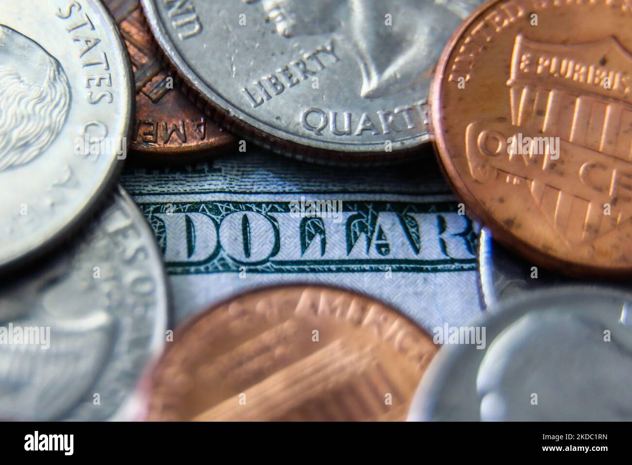 Dollars writing on a banknote is seen with coins in this illustration ...