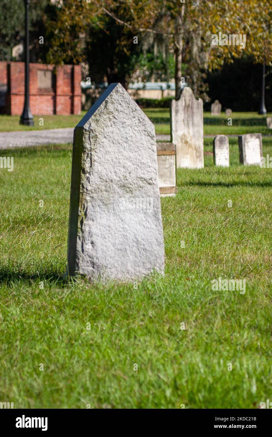 An Unmarked Gravestone on grass field on a sunny day, vertical shot ...