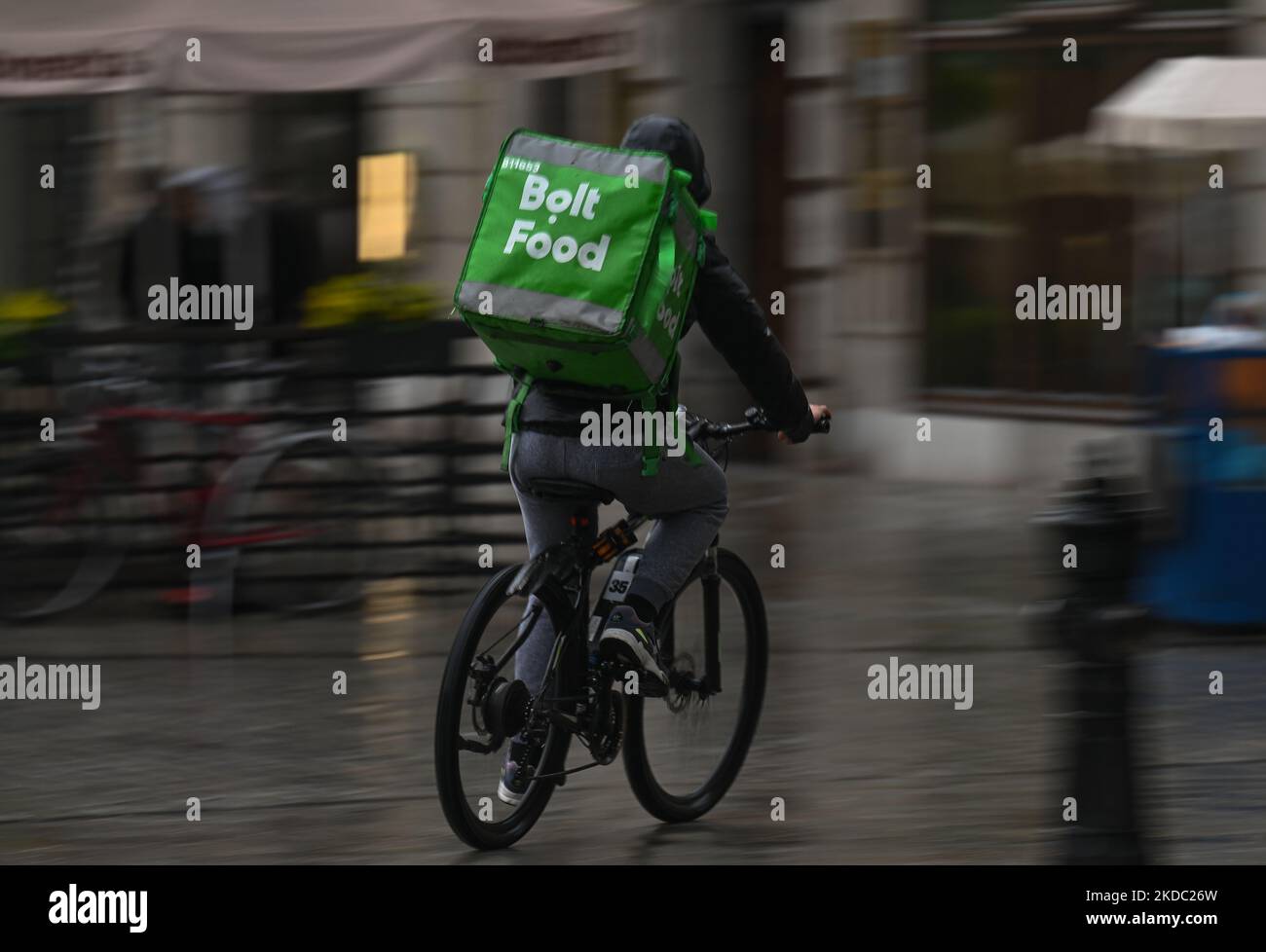 The Bolt Food courier rides a bike through the Market Square on a rainy ...
