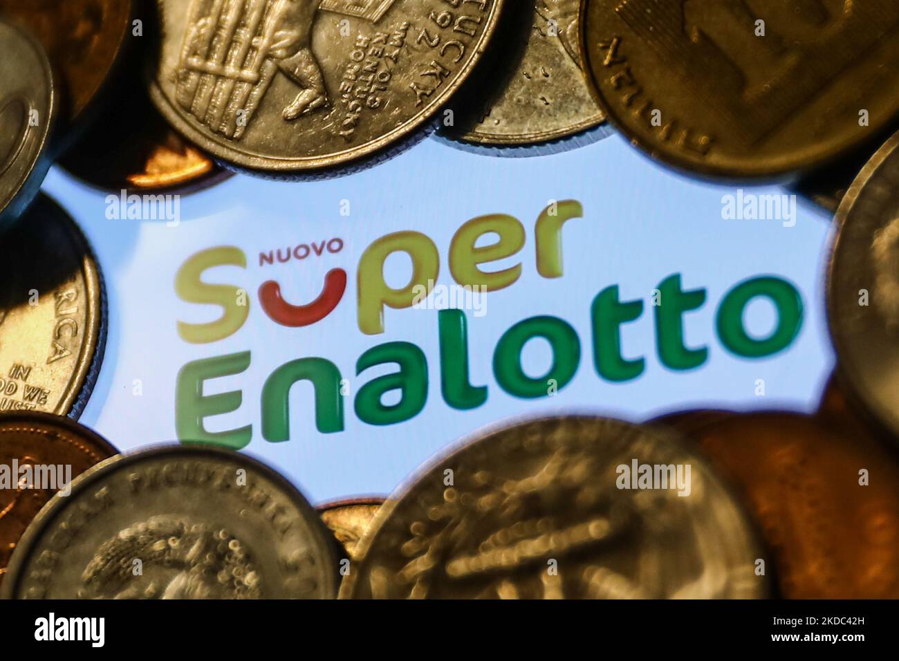 Super Enalotto logo displayed on a phone screen and coins are seen in ...