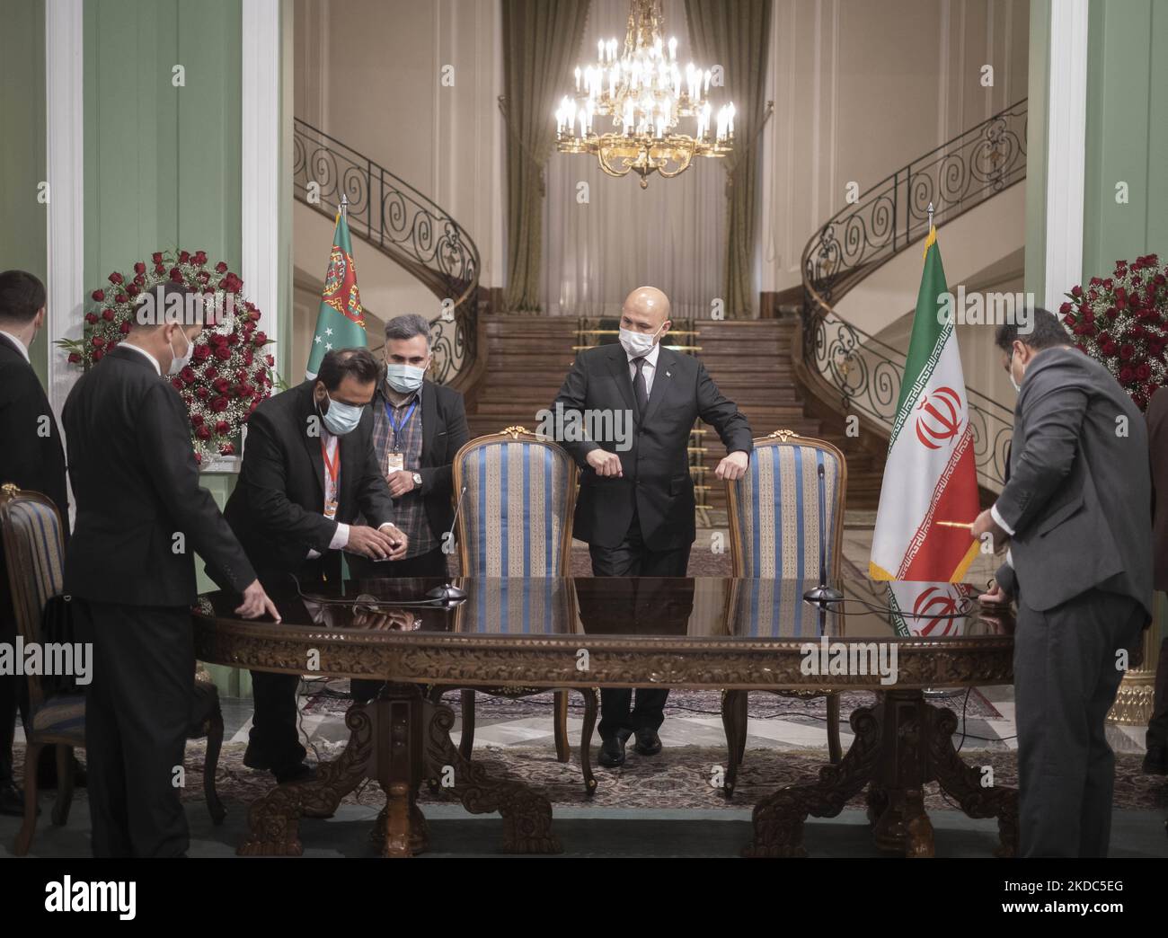 Iranian and Turkmen officials adjust a table before a ceremony for ...